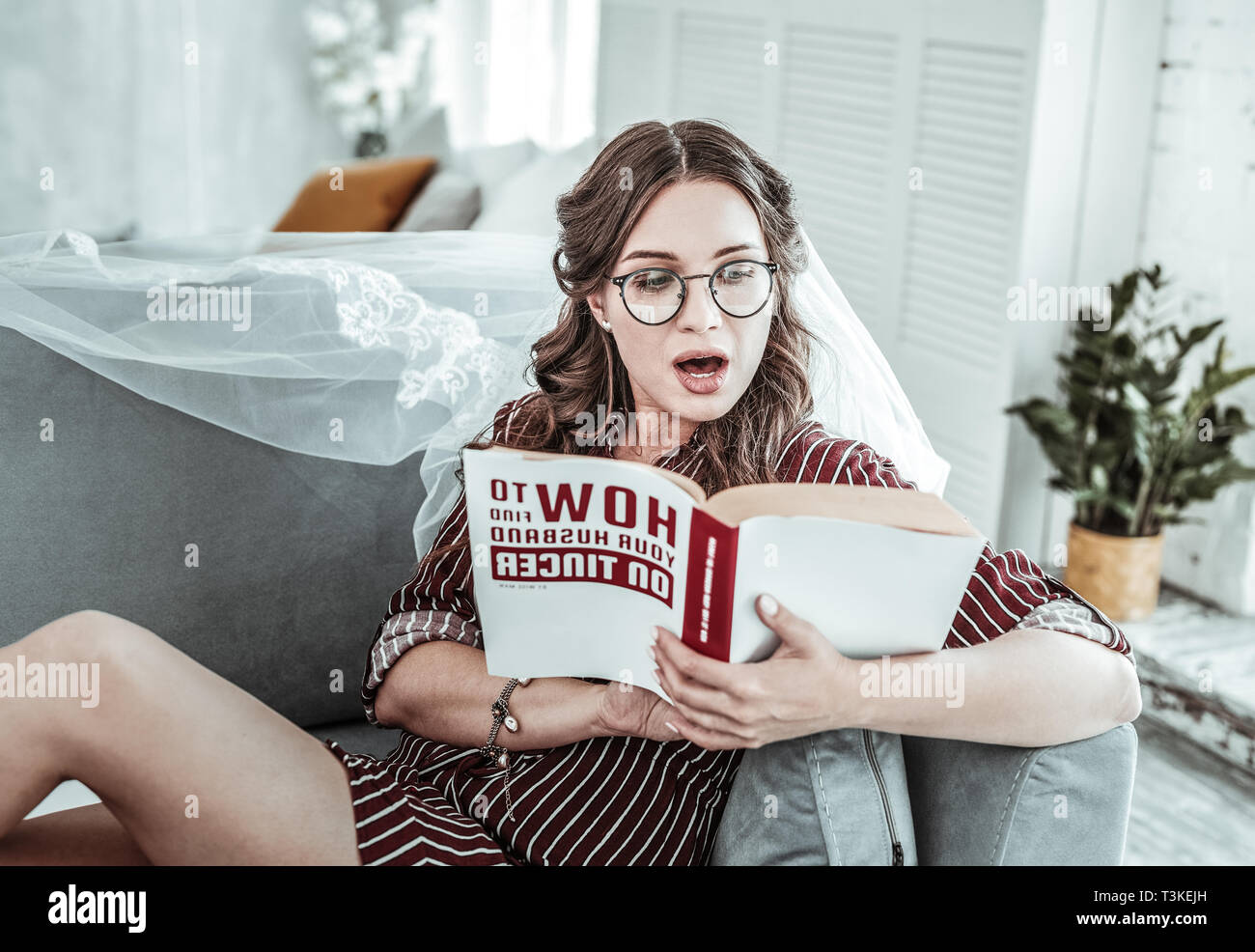 Emotional woman in a vail reading a book Stock Photo - Alamy