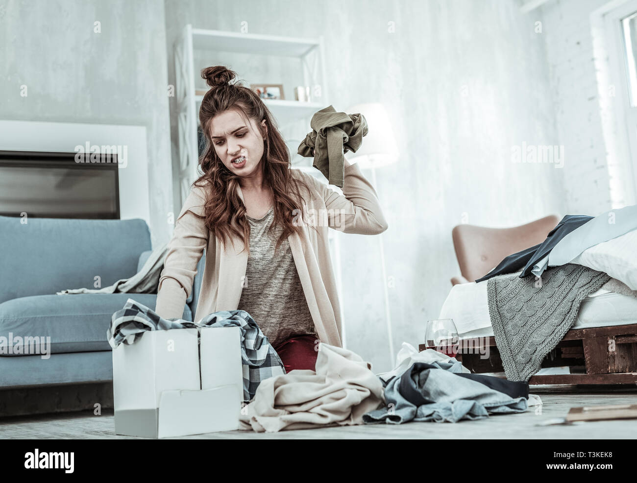 Angry woman getting rid of her husbands clothes Stock Photo - Alamy