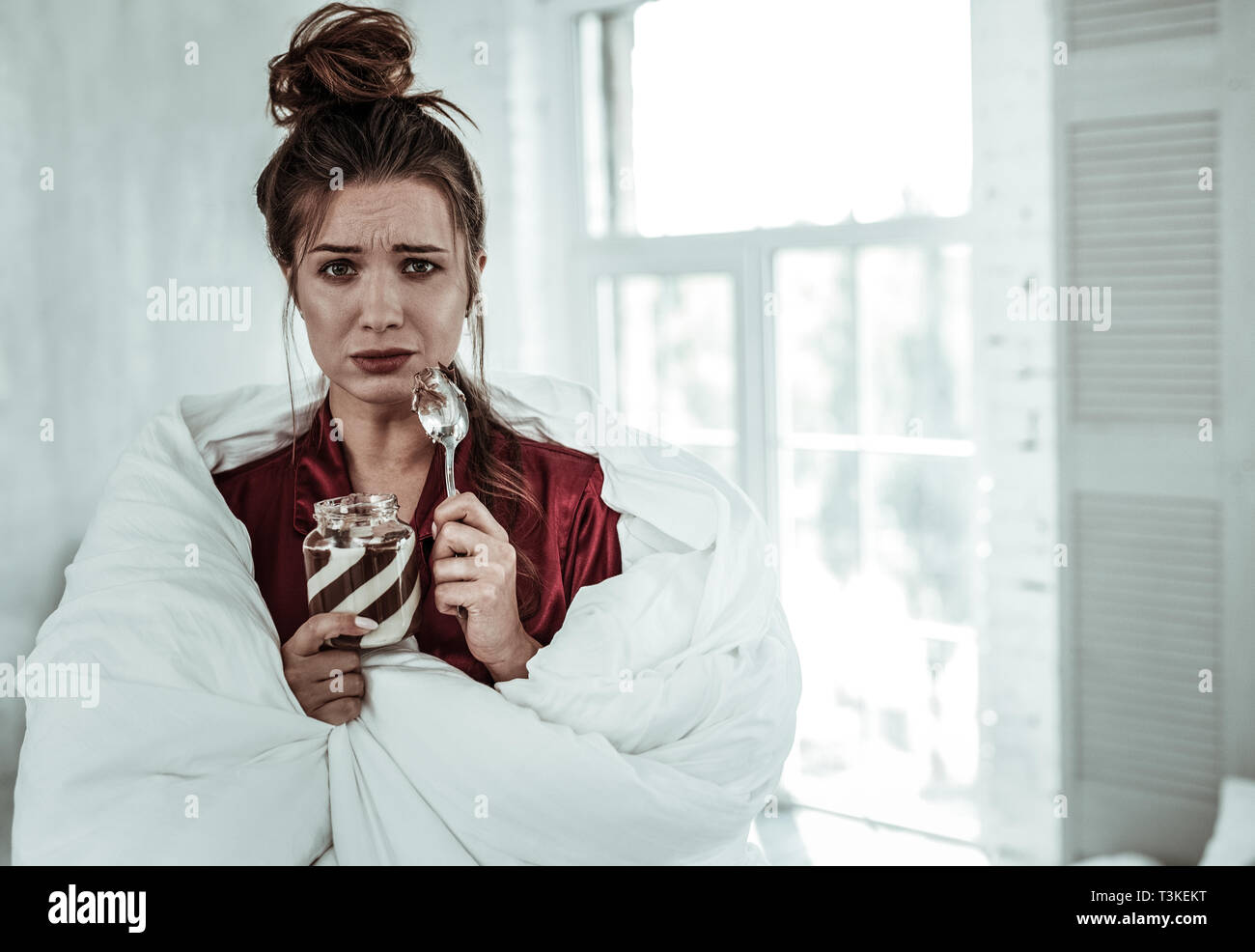 Sad woman eating the chocolate pasta to reduce the stress Stock Photo ...