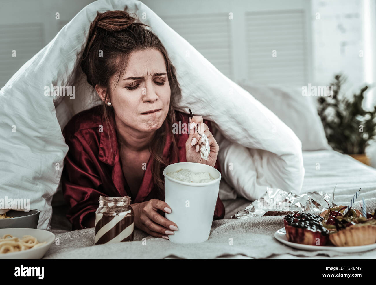 Sad woman eating ice cream hi-res stock photography and images - Alamy
