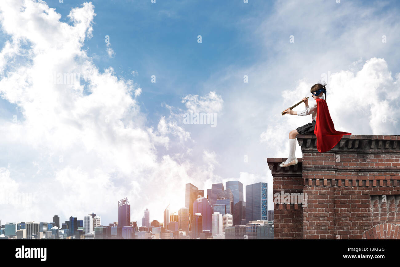 Girl power concept with cute kid guardian against cityscape background ...