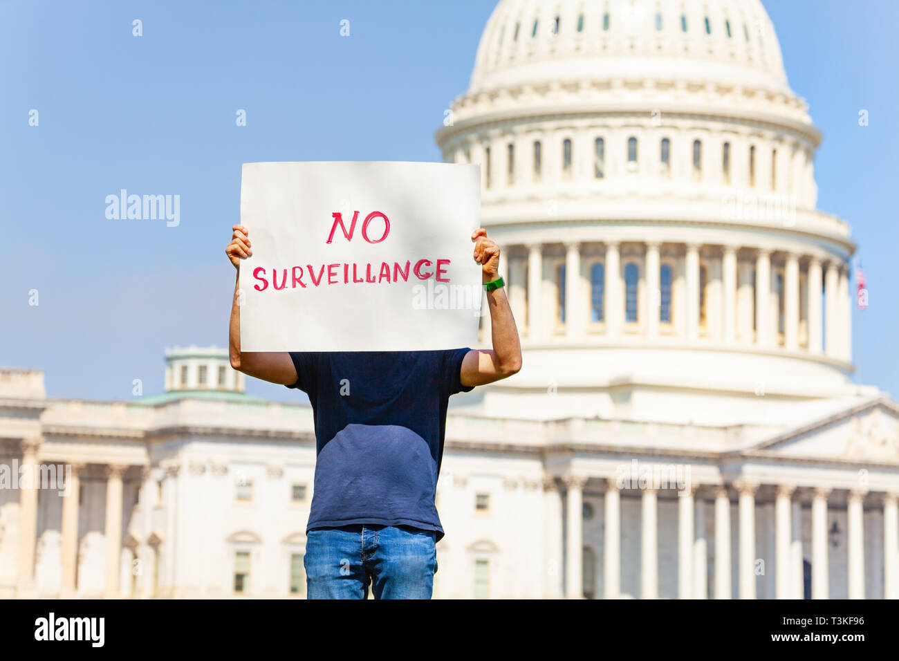 Protester holding sign saying no surveillance hiding face Stock Photo ...