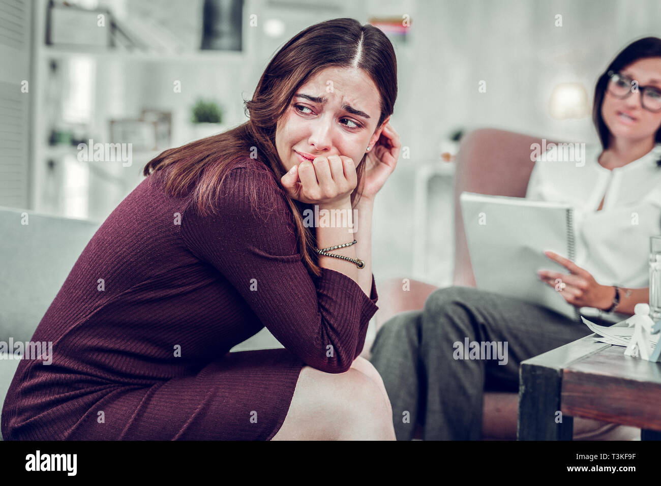 Overemotional woman crying while sharing problem with therapist Stock ...