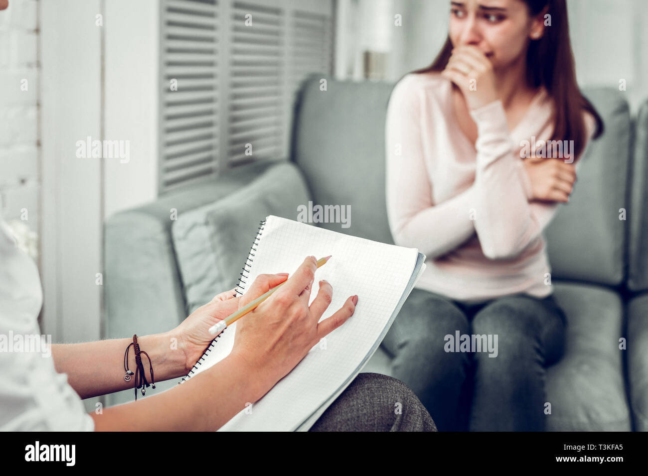 Therapist making notes while listening to crying stressed client Stock ...