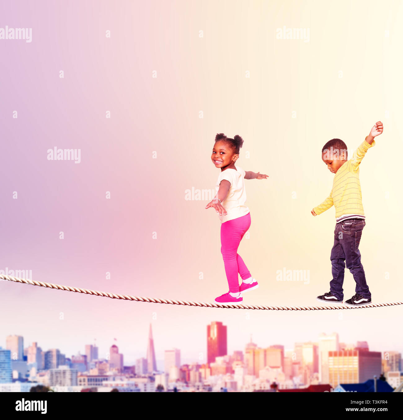 Boy and girl walking on the rope city Stock Photo - Alamy