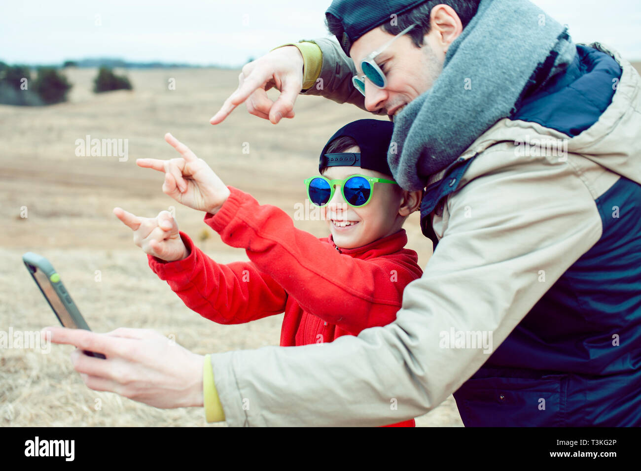 young father with his son having fun outside in spring field, happy ...