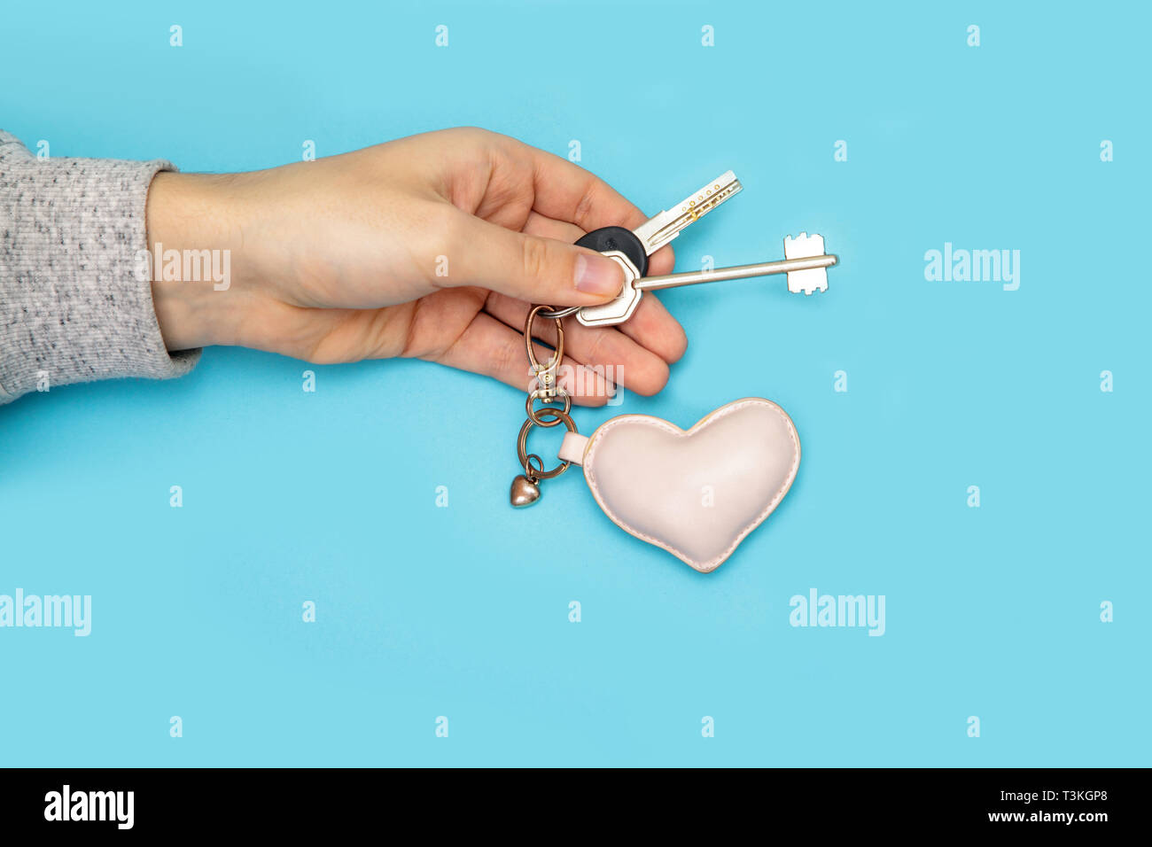 Man arm out holding a new key. Men's hands give the keys on a blue ...