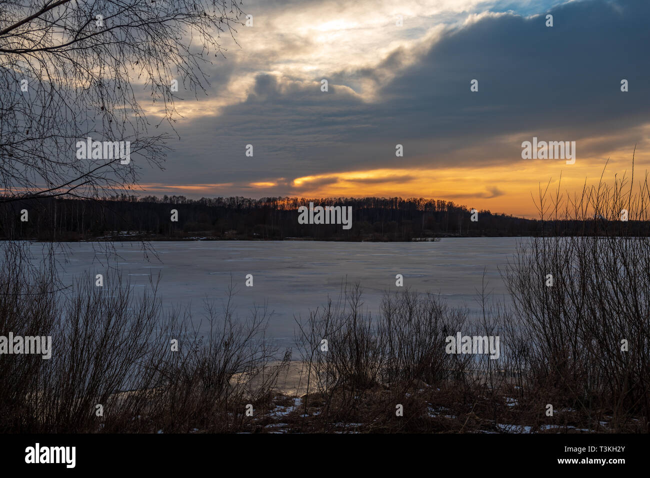 orange red sunset in winter in woods with calm water in river Stock ...