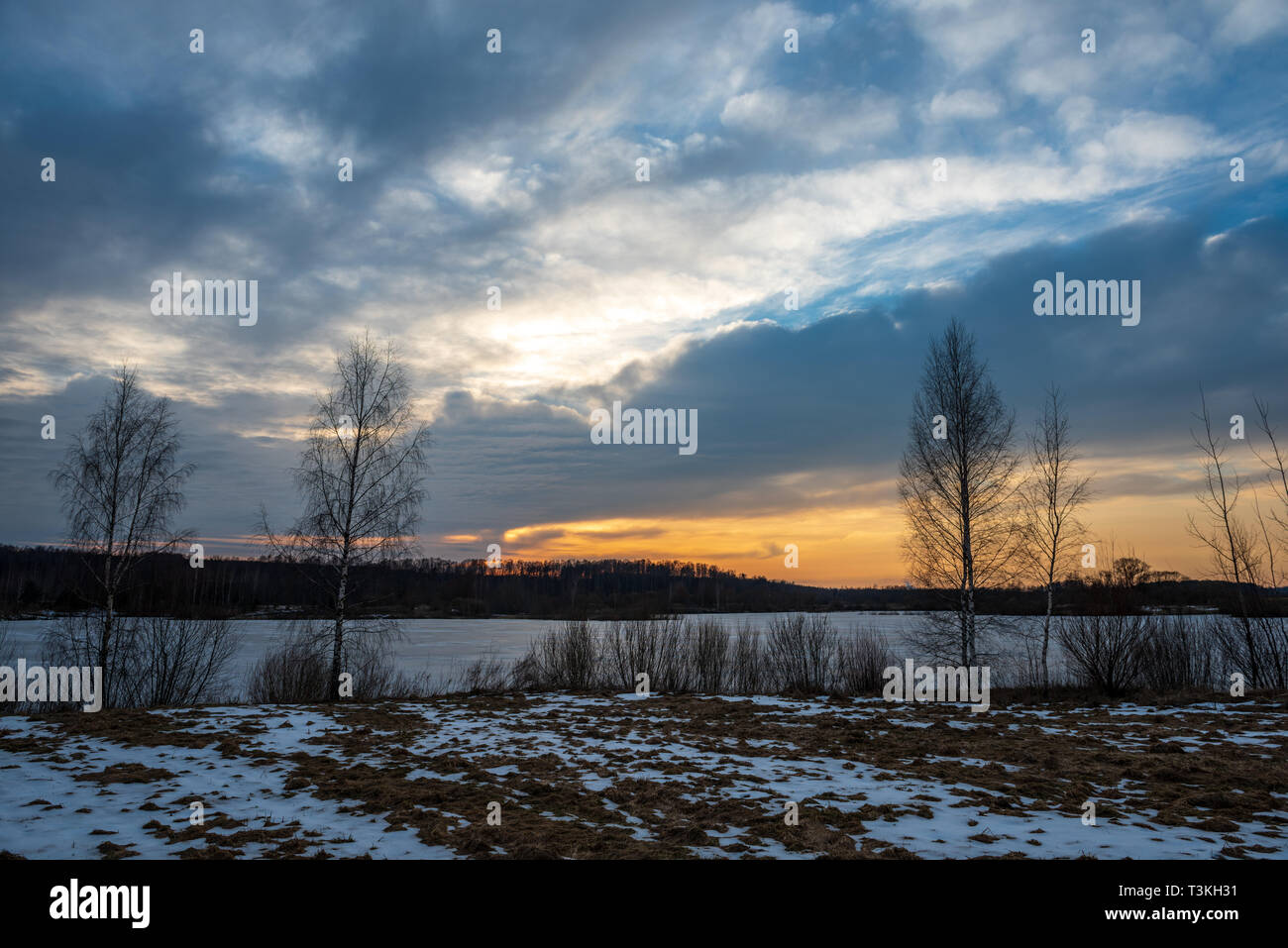 orange red sunset in winter in woods with calm water in river Stock ...