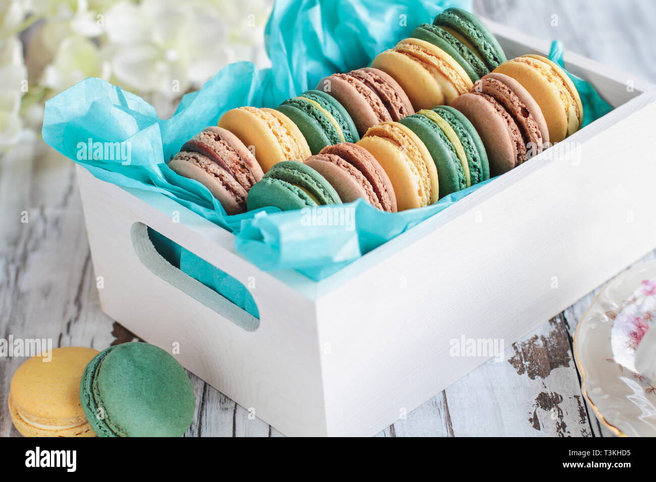 Assortment of fresh french macarons packaged in a pretty white wooden ...