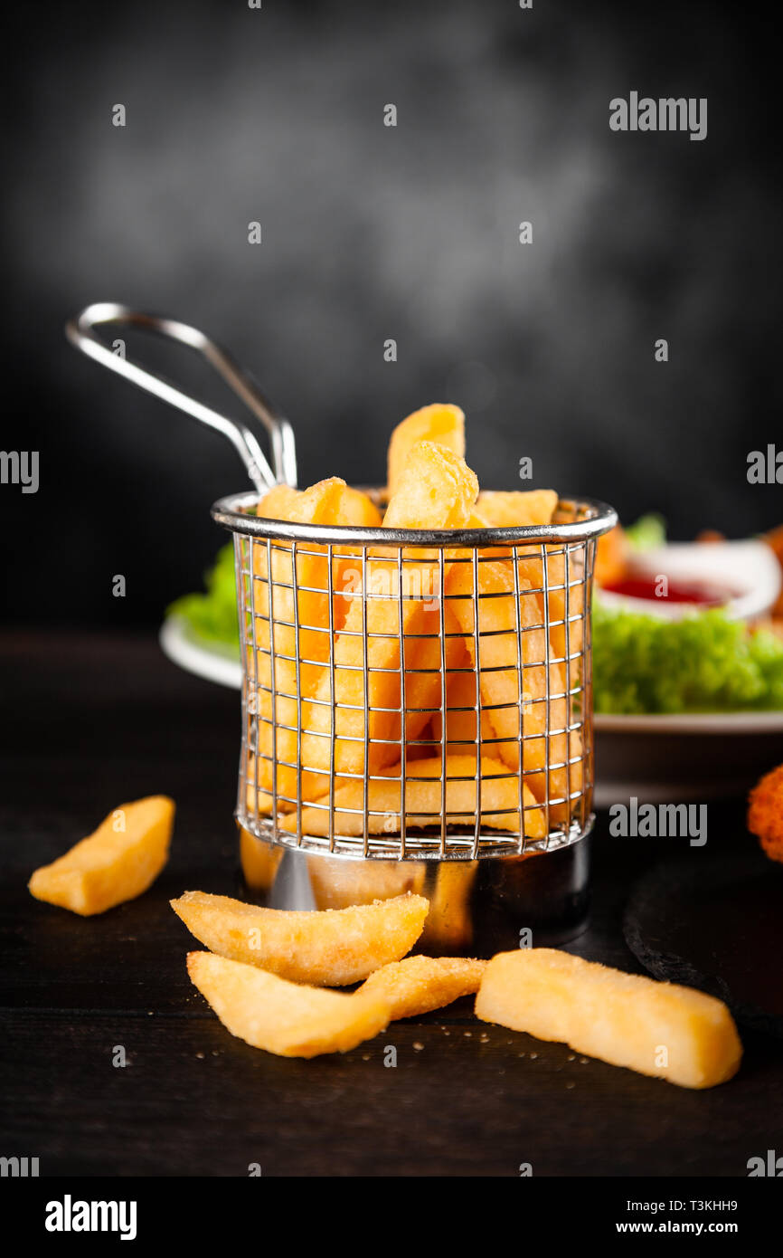 French fries in a metal holder on dark background Stock Photo - Alamy
