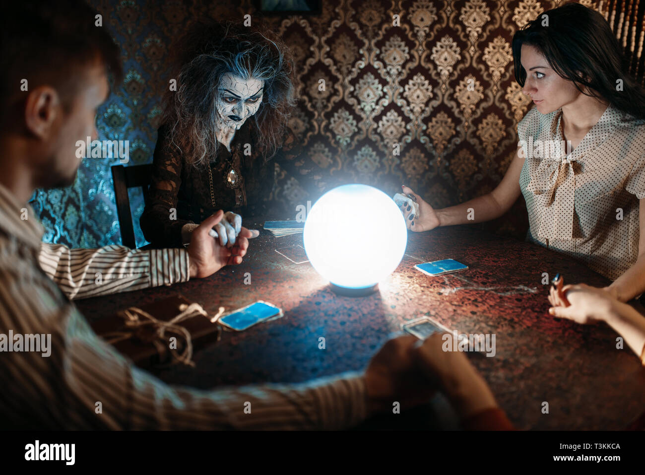 Witch, man and woman on spiritual seance Stock Photo - Alamy