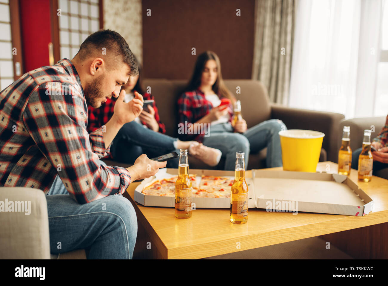 Sad friends drinks beer at the boring home party Stock Photo - Alamy