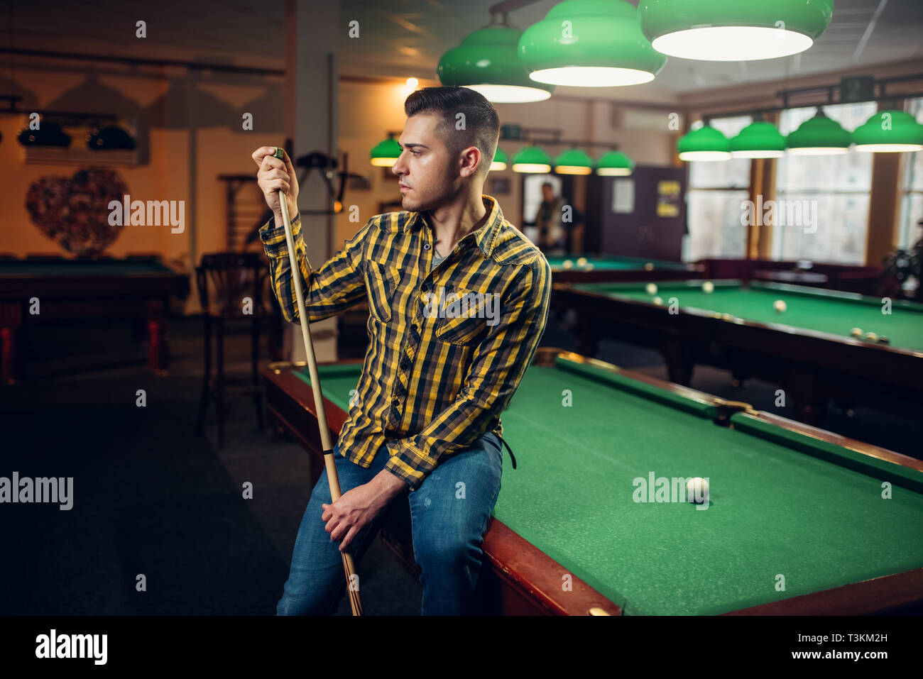 Male billiard player with cue poses at the table Stock Photo - Alamy