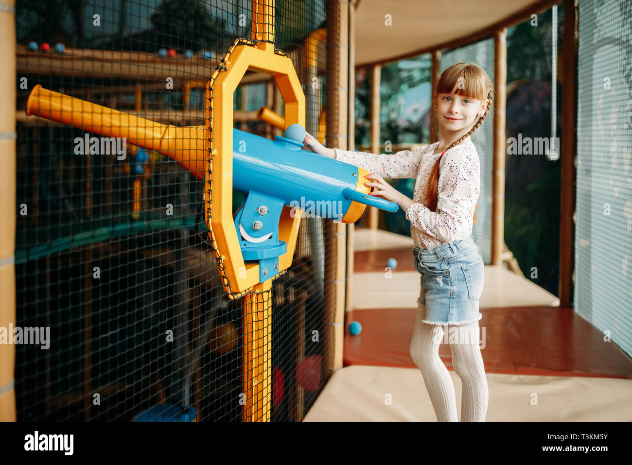 Girl plays with air gun in children game center Stock Photo - Alamy