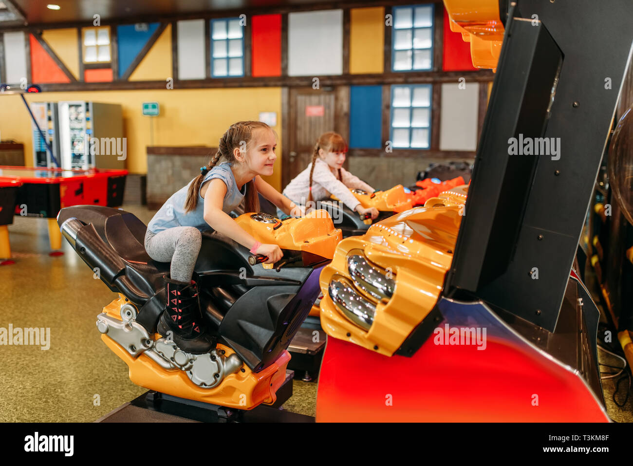 Two girls plays game machine, entertainment center Stock Photo - Alamy