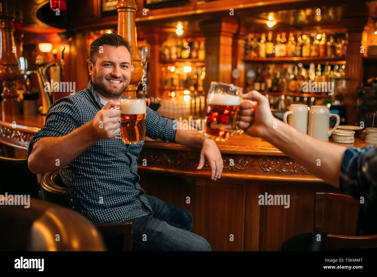 Two male friends drinks beer at the counter in pub Stock Photo - Alamy