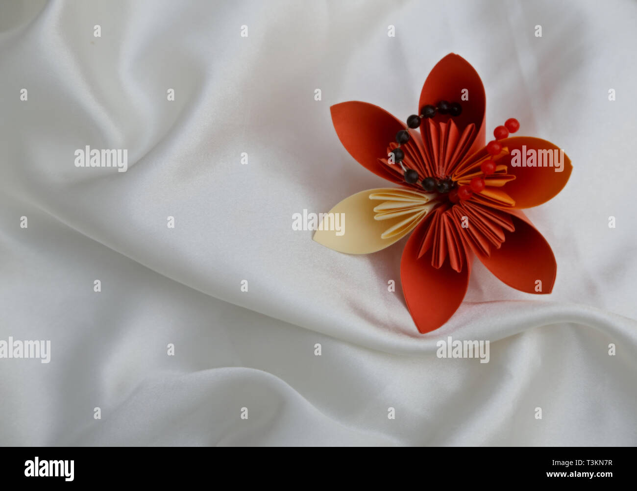 Self made beautiful and decorative paper flowers with pearls on a satin ...