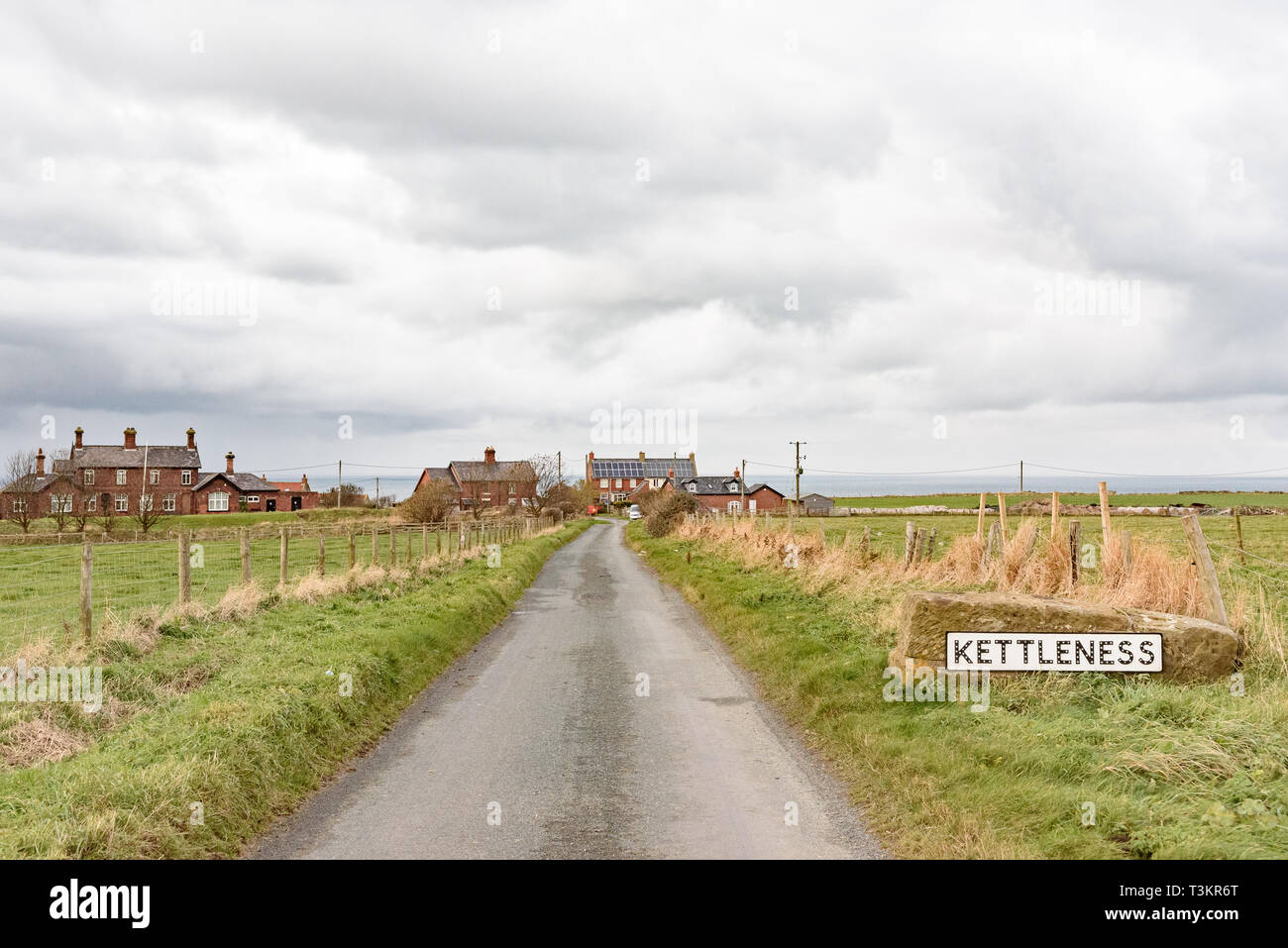 The main sign and road into Kettleness with housing Stock Photo - Alamy