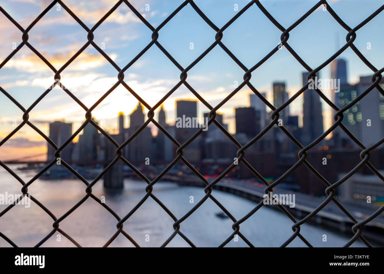 New York City skyline seen through a chainlink fence in Manhattan NYC ...