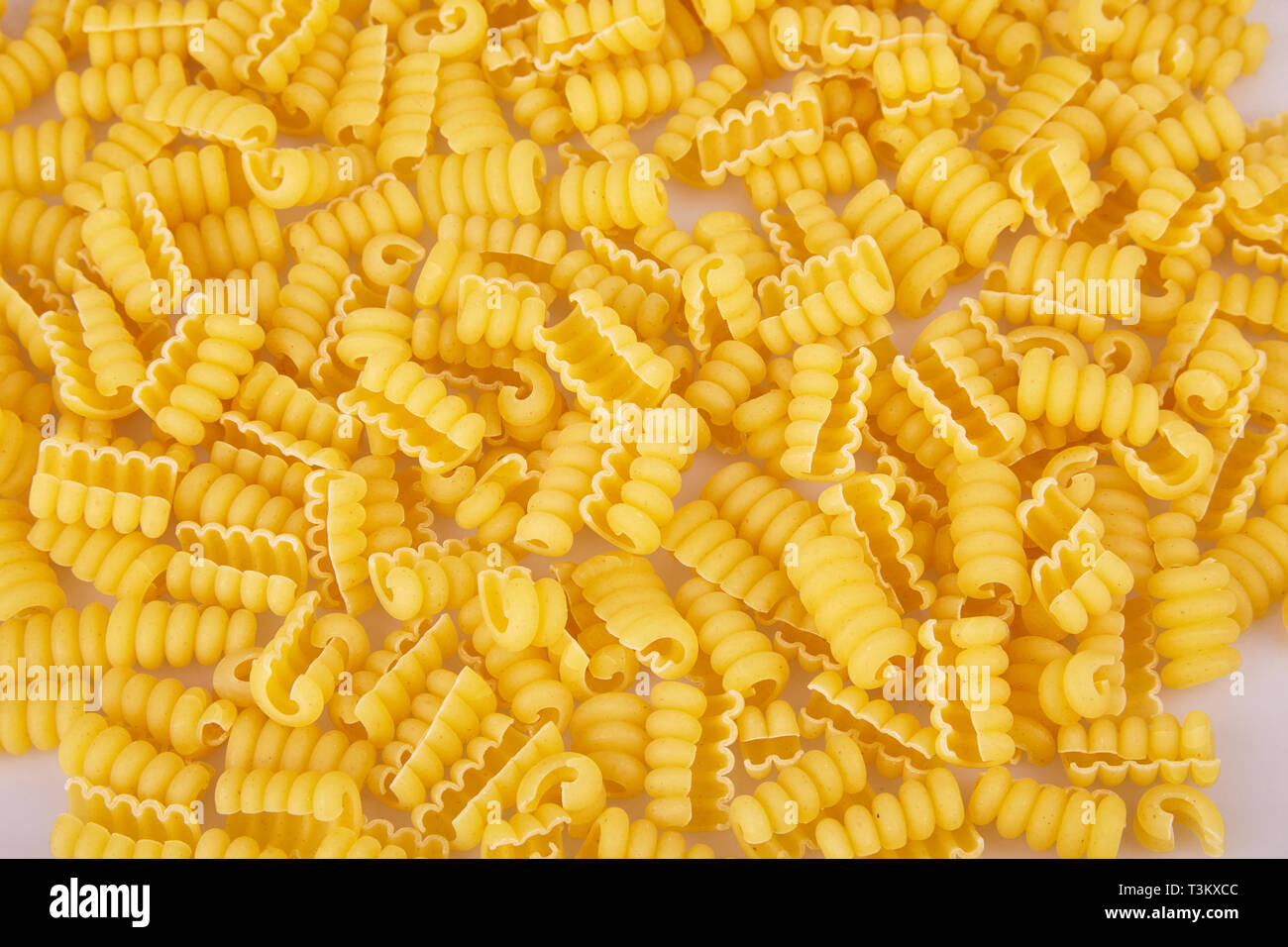 Raw pasta background. Uncooked pasta tubules background. Food ...