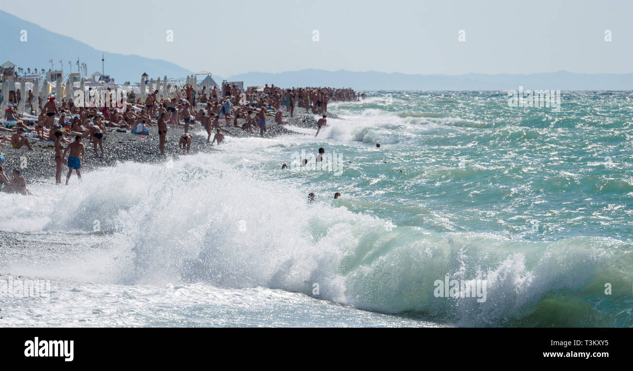 A small storm on the beach, filled with people. Seascape with blue sky ...