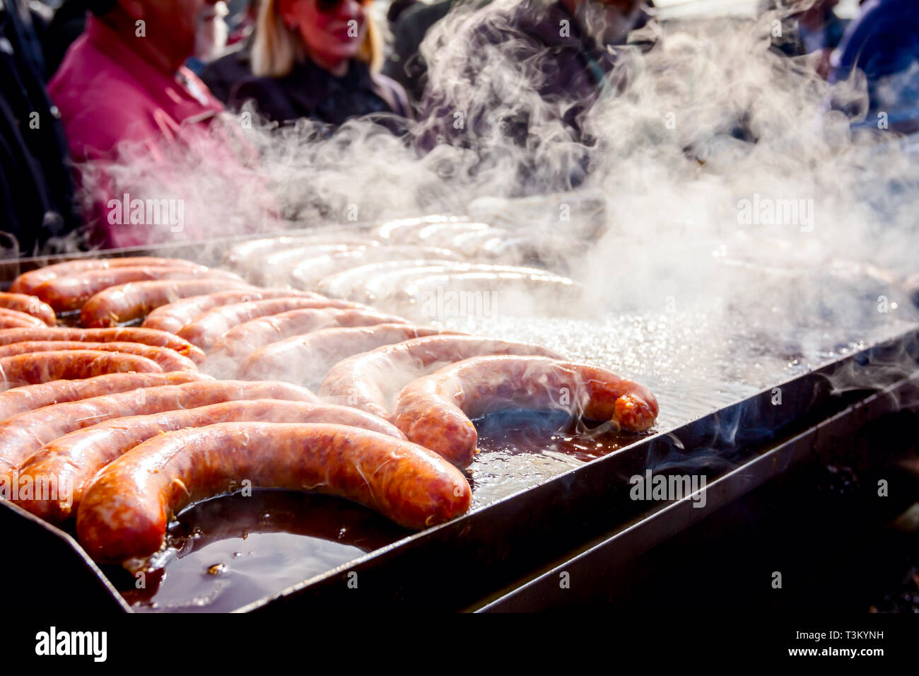 Traditional homemade pork sausages are simmering on the big barbecue ...