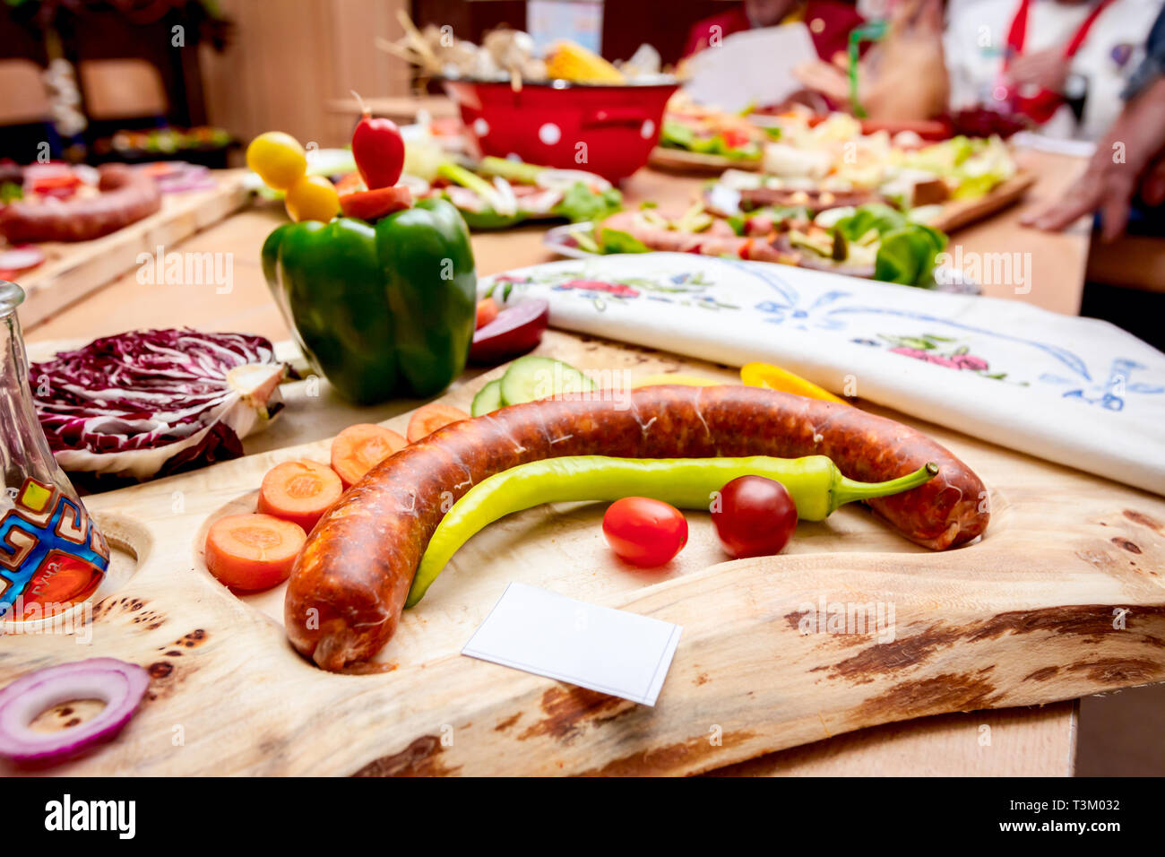 Decorated raw sausage with fresh vegetables is exposed on traditional ...