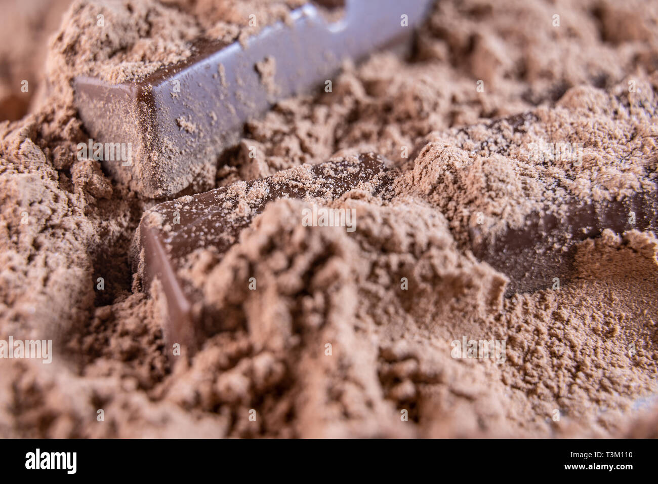 Milk sweet chocolate bar on chocolate powder Stock Photo - Alamy