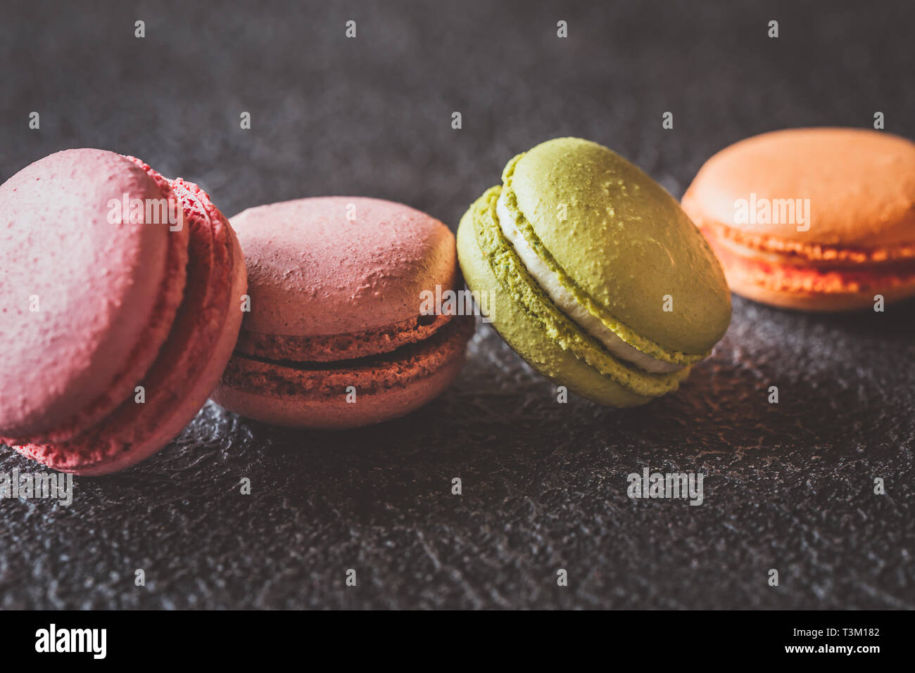 Colorful macarons on the dark background Stock Photo - Alamy