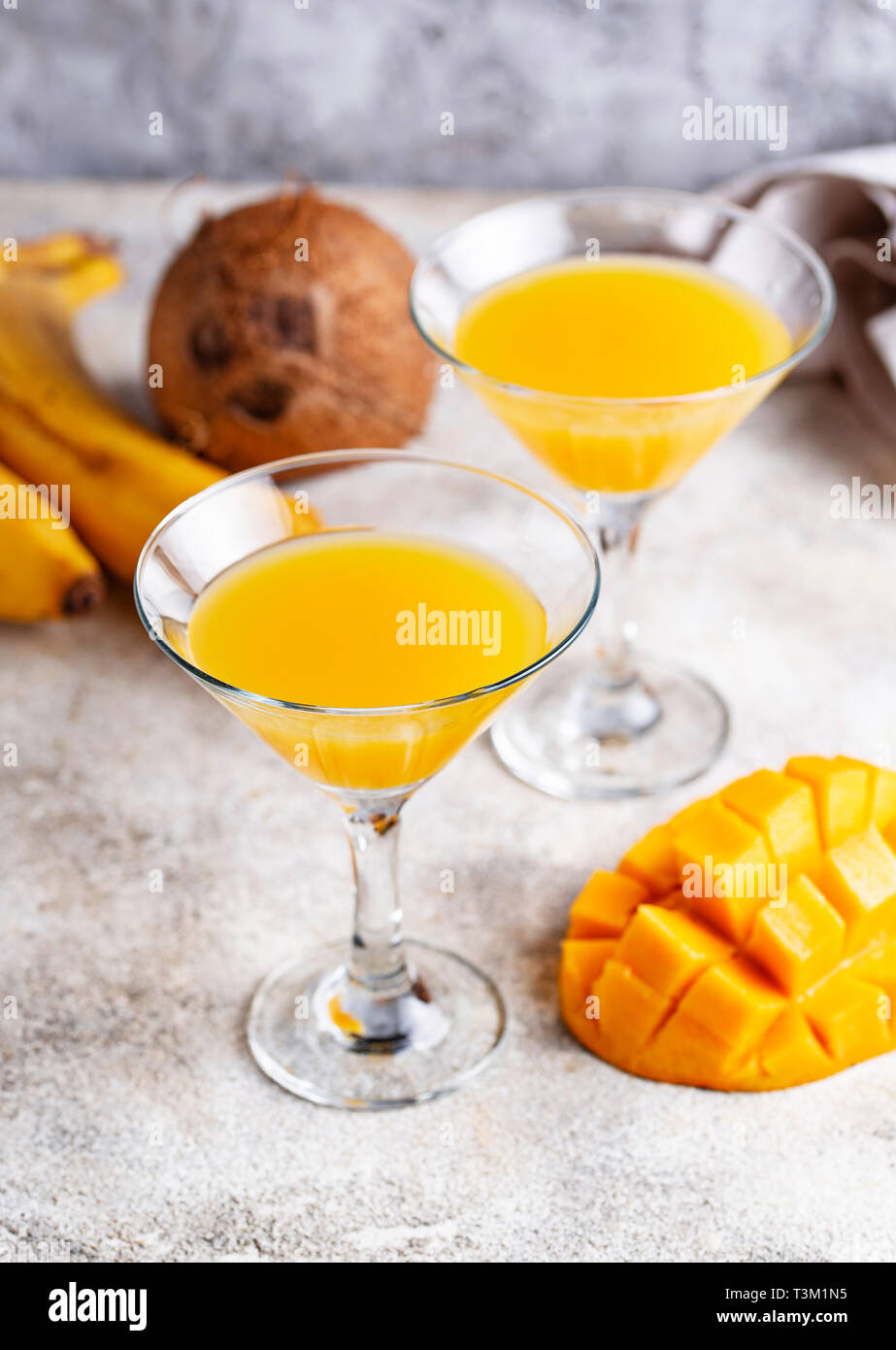 Tropical fruit cocktail with mango on light background Stock Photo - Alamy