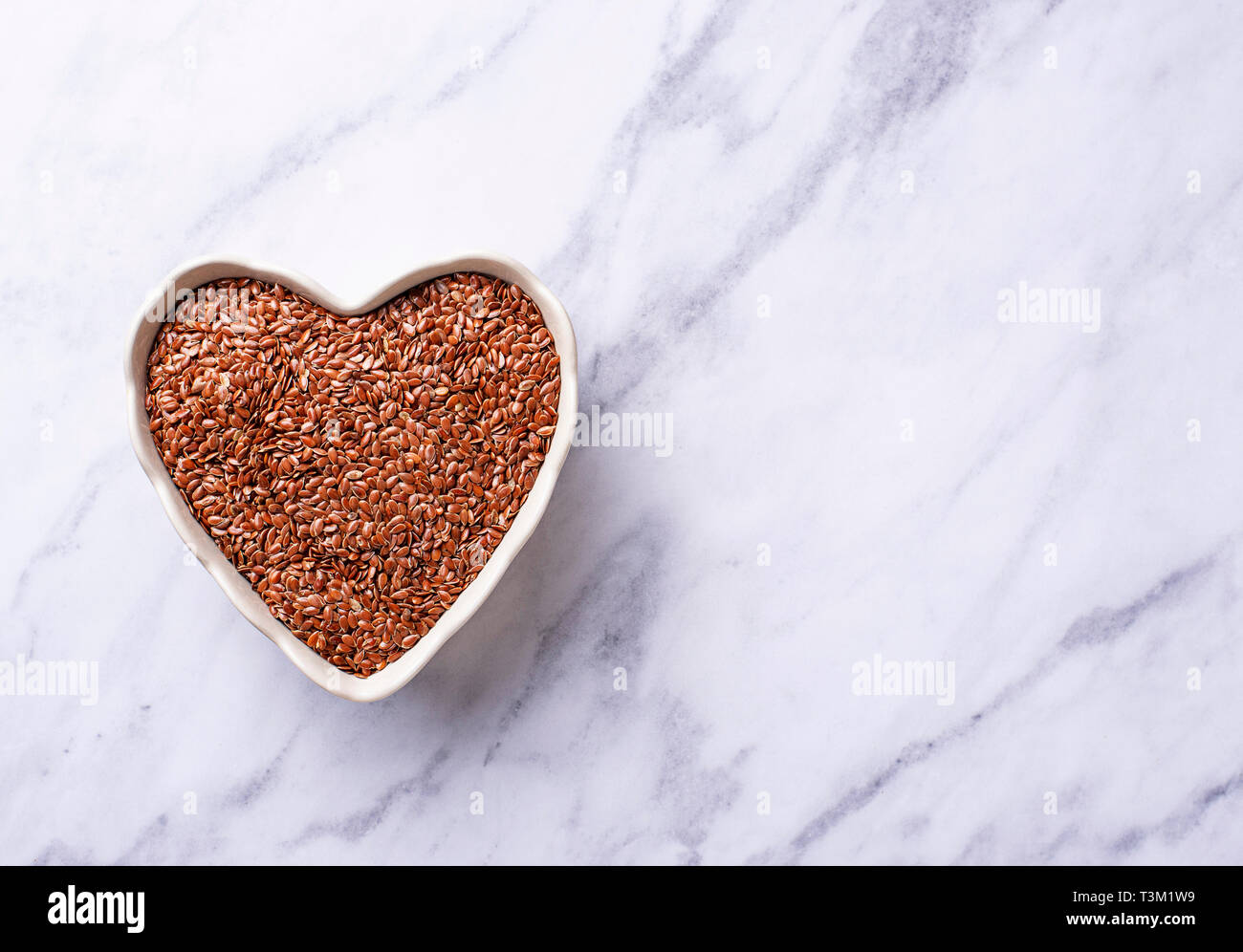 Flax seeds in heart shape bowl on marbled background Stock Photo - Alamy