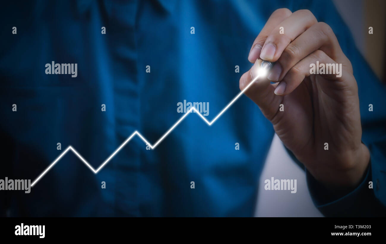 Businessman using pen drawing graphics line growing graph. Describe the ...