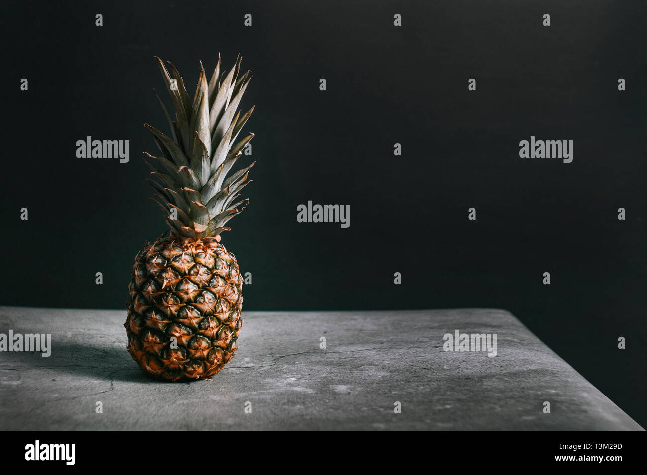 Beautiful pineapple in a studio on a stone surface Stock Photo - Alamy