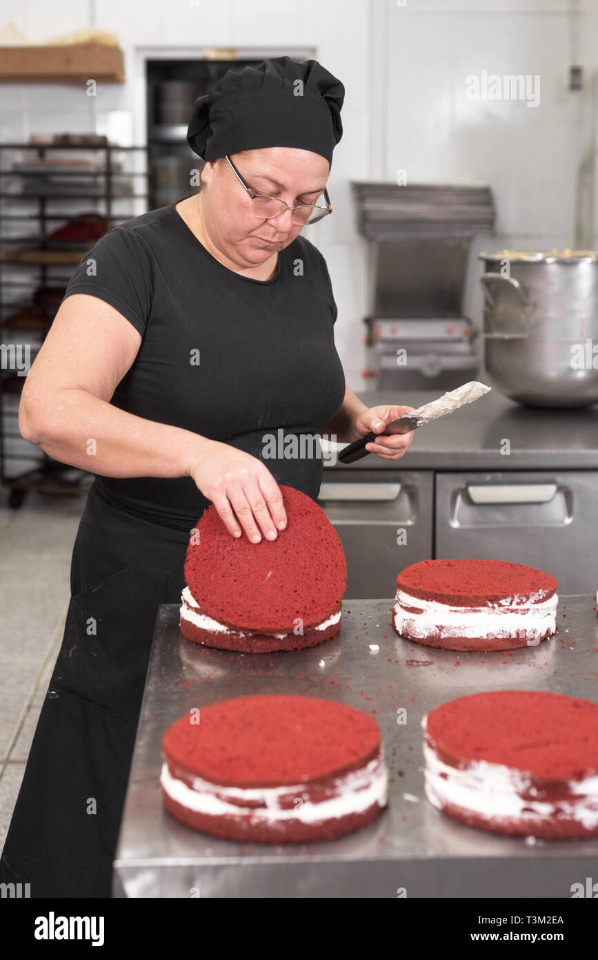 Woman pastry chef smiling and working happy, making cakes at the pastry ...