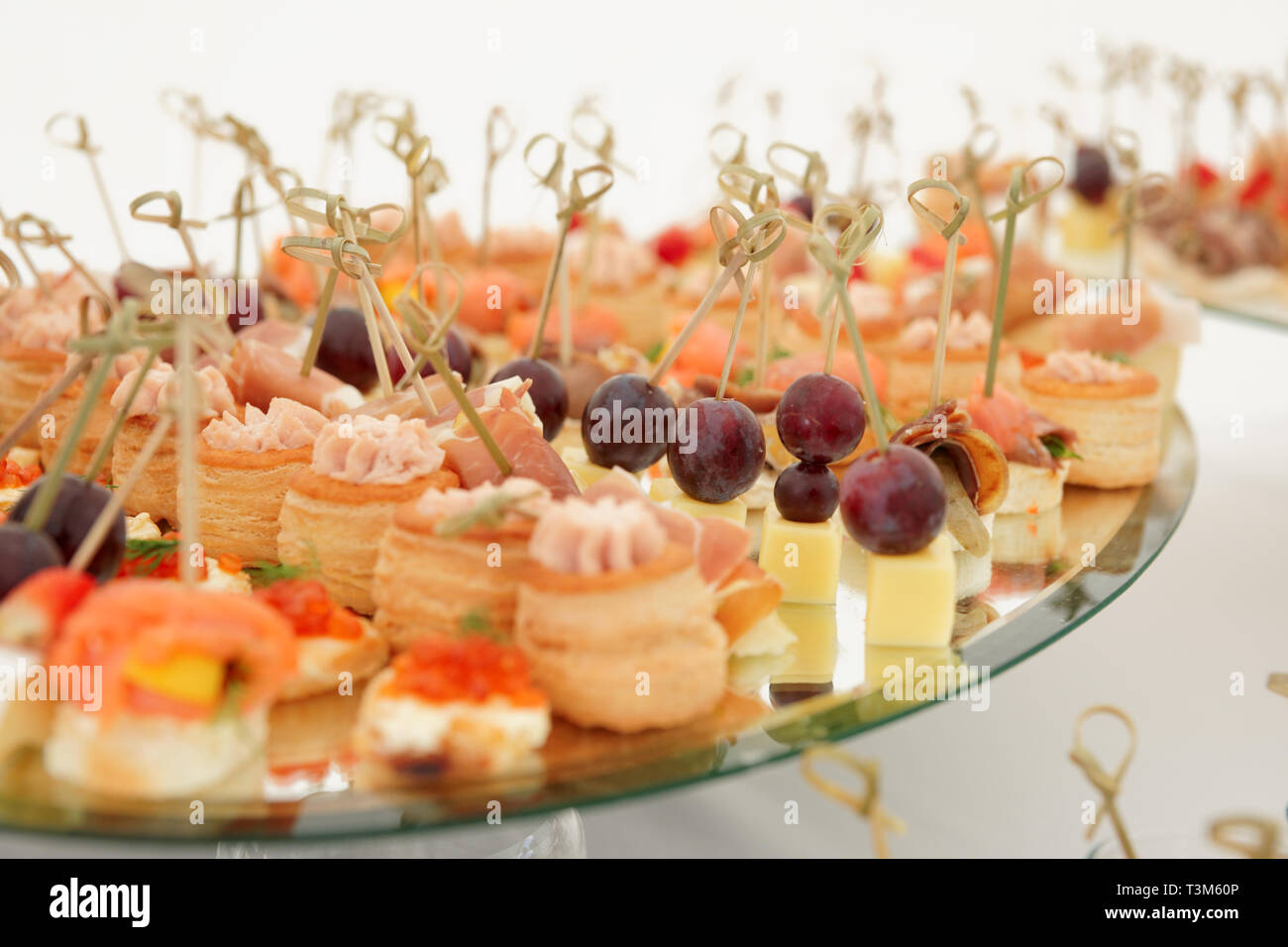 Meat, fish and cheese banquet snacks on platter Stock Photo - Alamy
