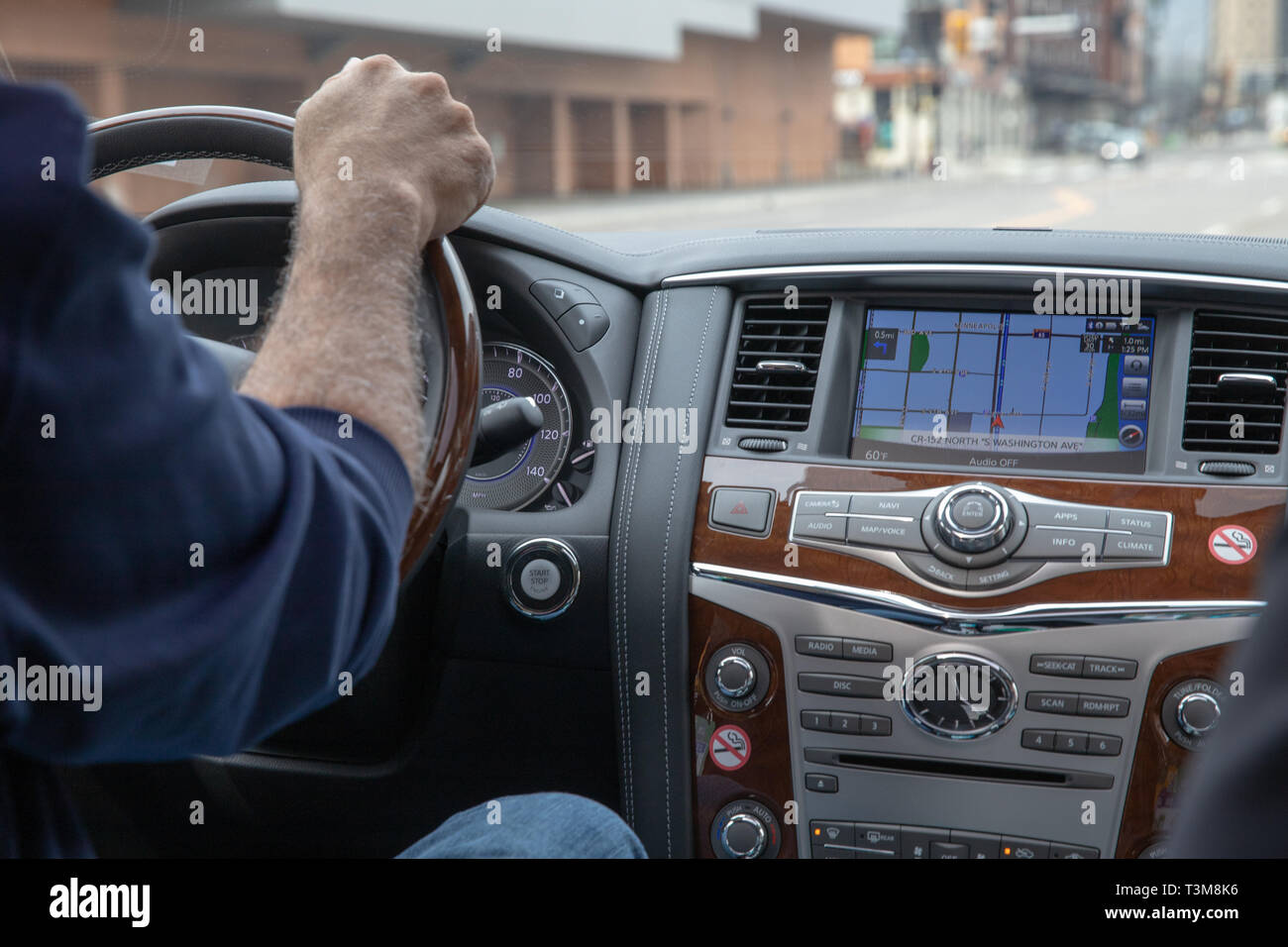 Over the shoulder POV of driver driving a luxury modern vehicle down a ...