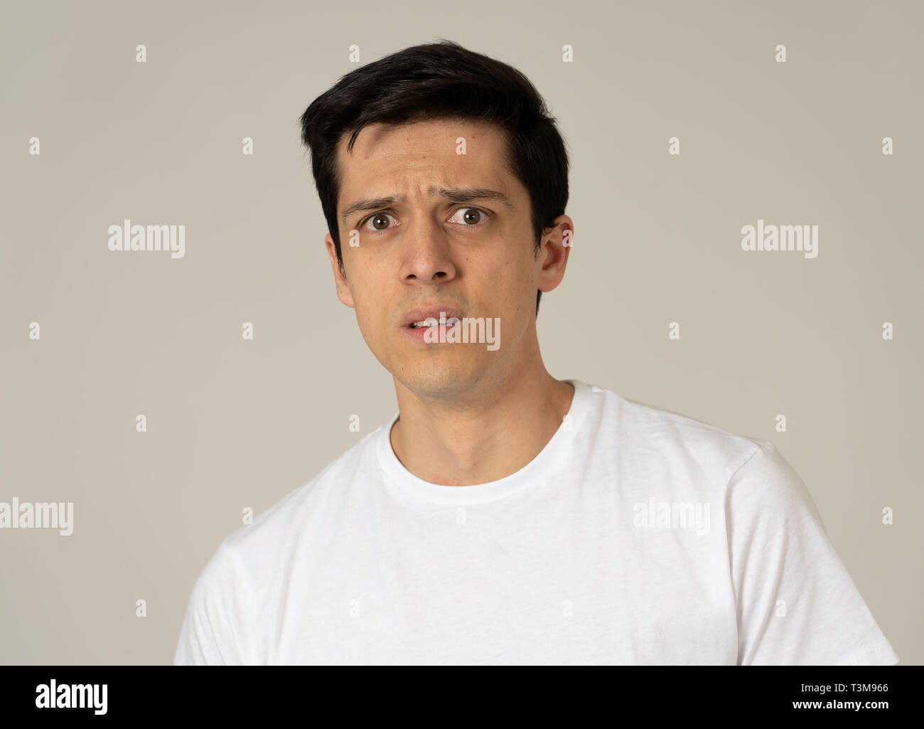 Young man feeling scared and shocked making fear, anxiety gestures ...