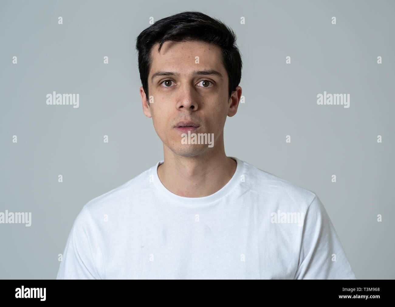 Young man feeling scared and shocked making fear, anxiety gestures ...