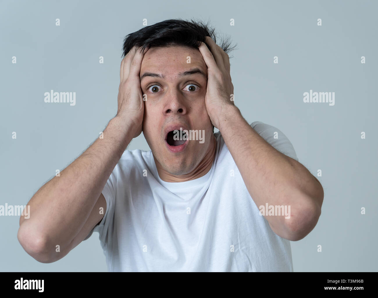 Young man feeling scared and shocked making fear, anxiety gestures ...