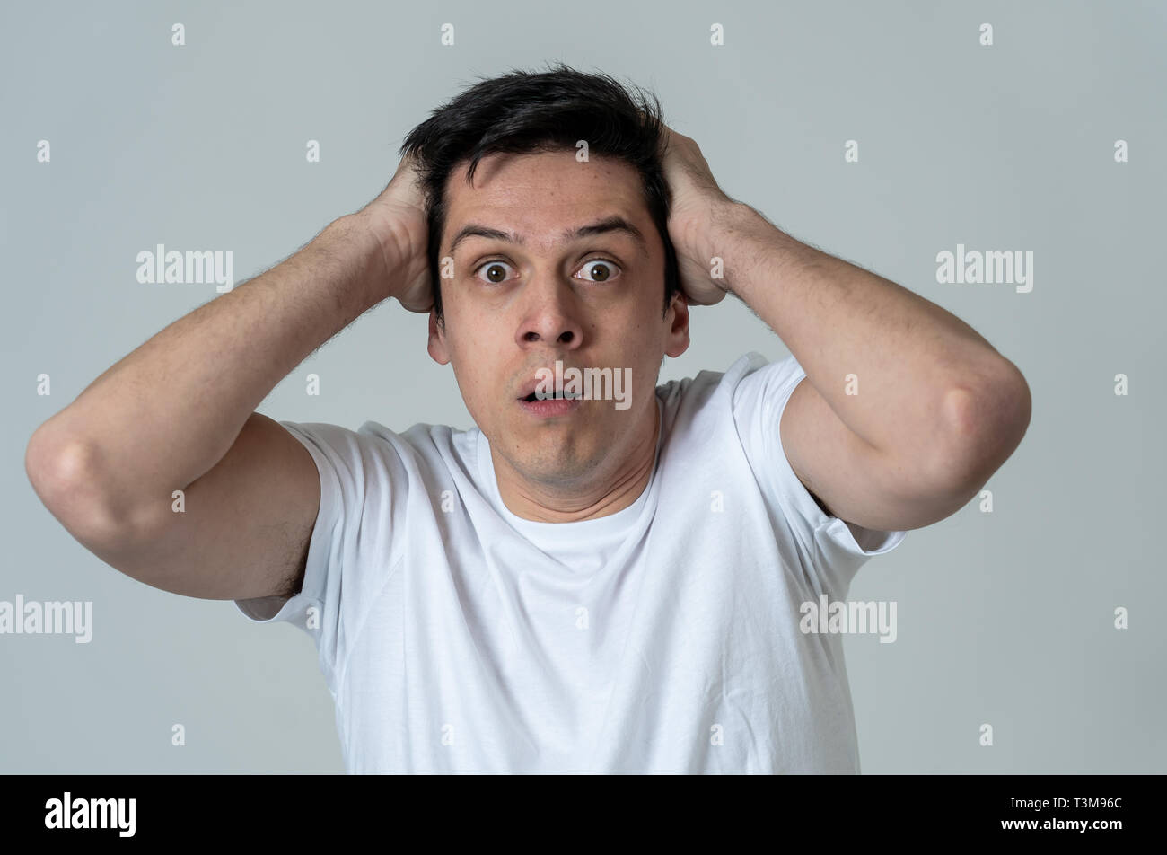 Young man feeling scared and shocked making fear, anxiety gestures ...