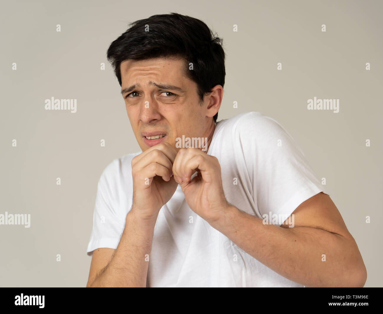 Young man feeling scared and shocked making fear, anxiety gestures ...