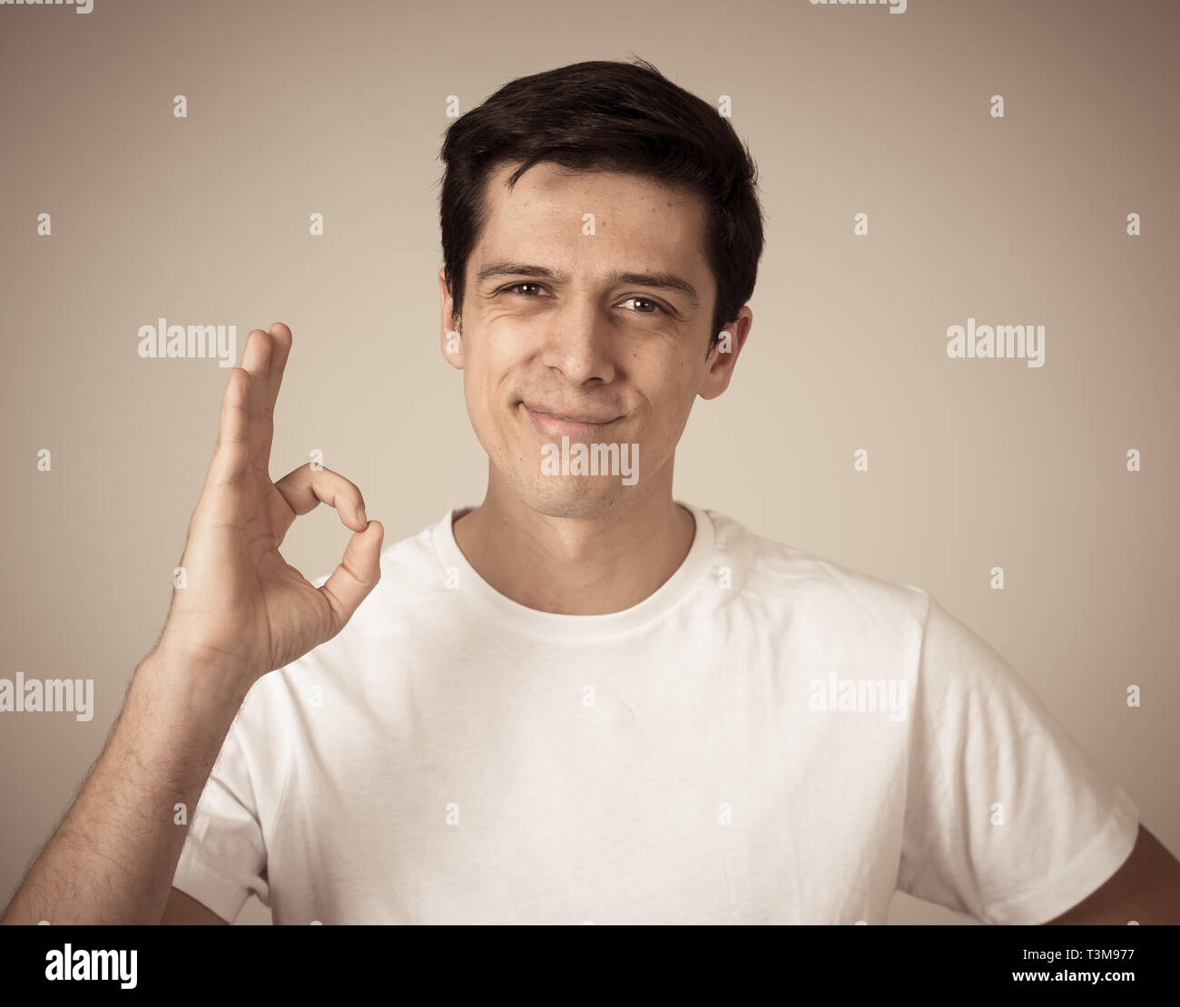 Close up portrait of young caucasian man smiling and doing OK sign ...