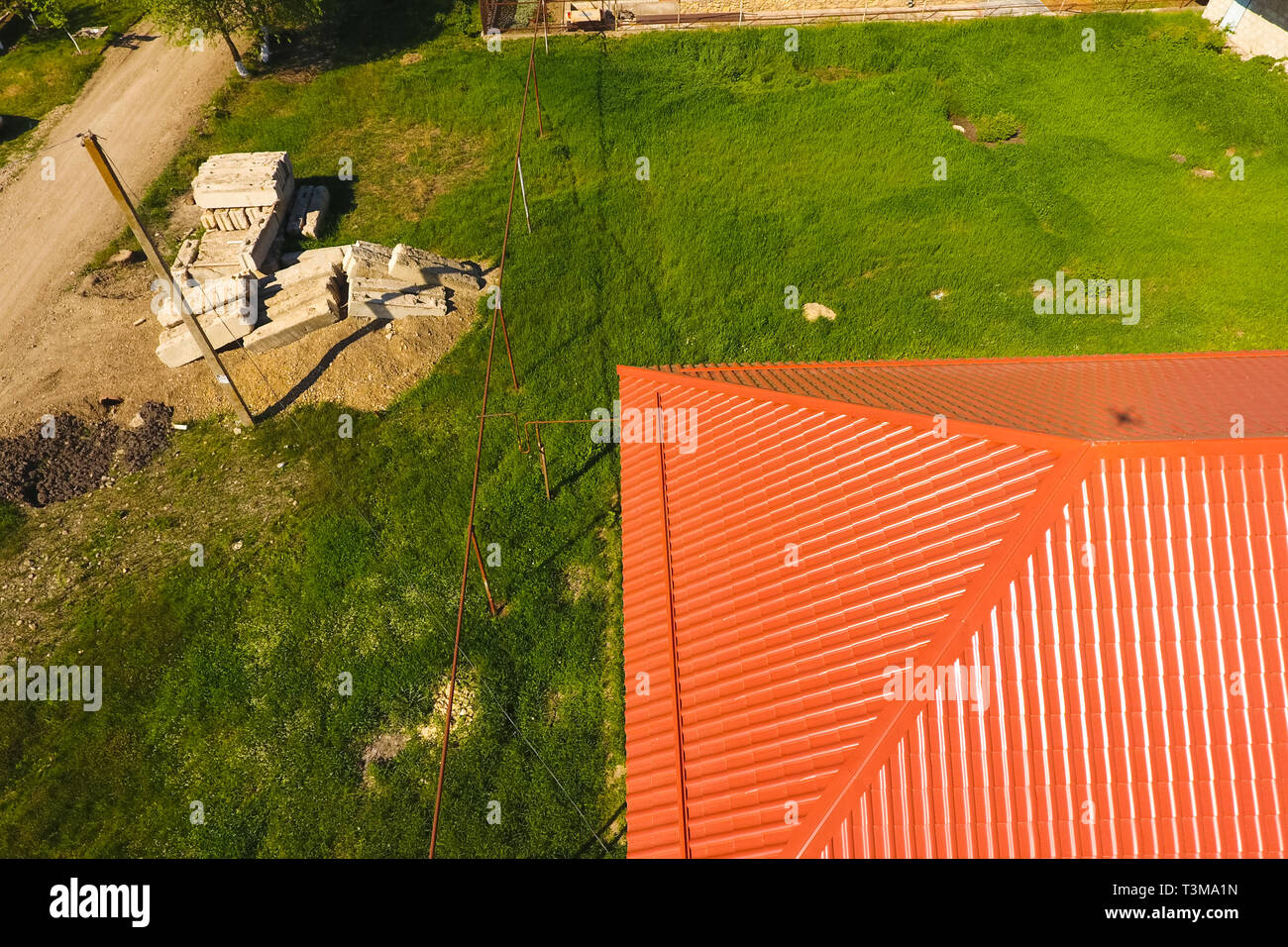 House with an orange roof made of metal, top view. Metallic profile ...