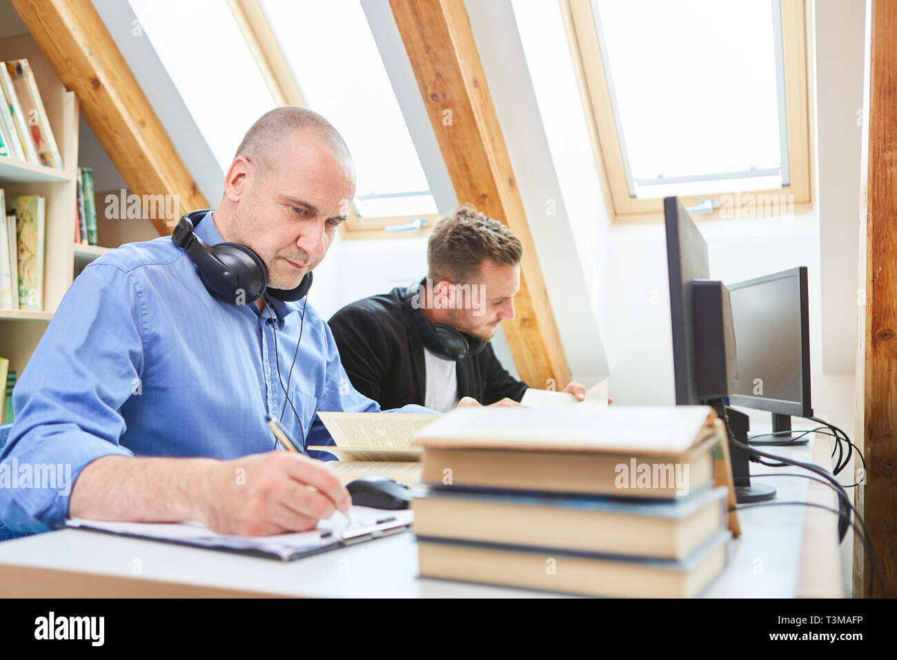 Two men learn together or write a test in the community college Stock ...