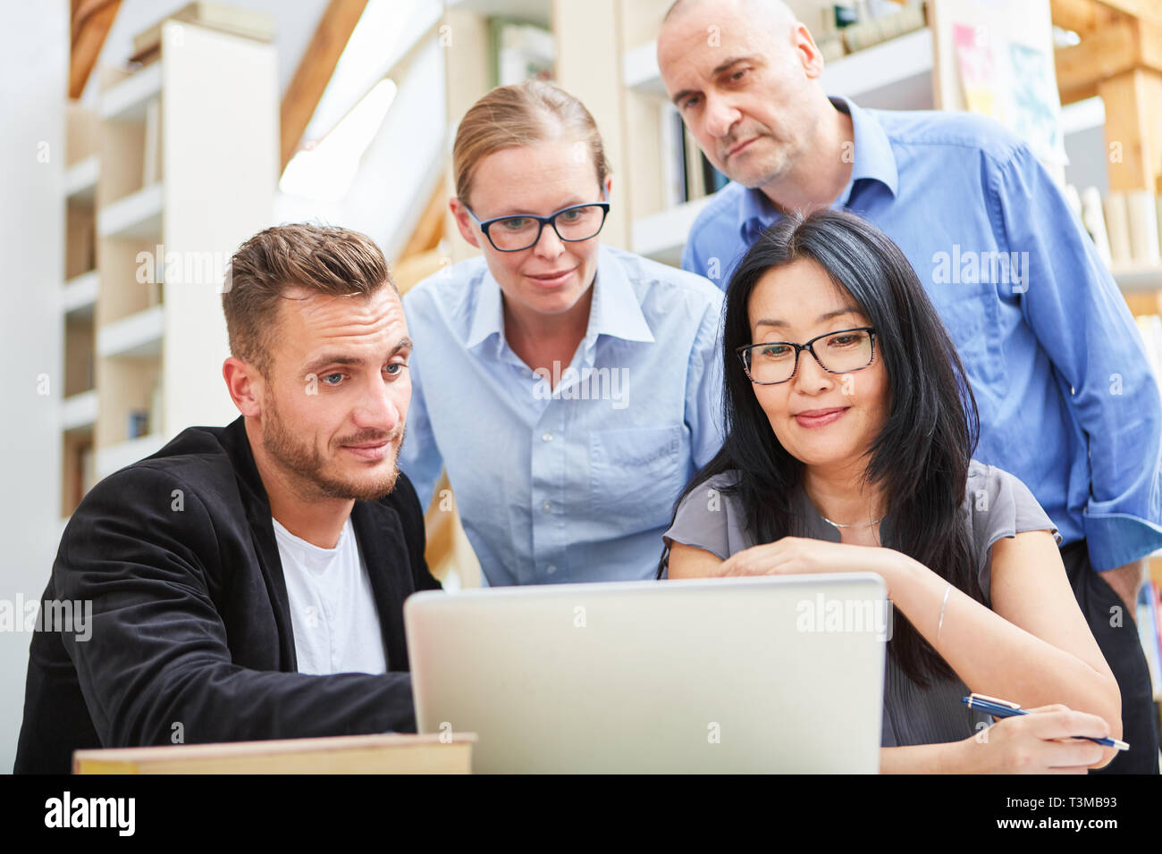 Young people as a developer team work together on laptop computer in ...