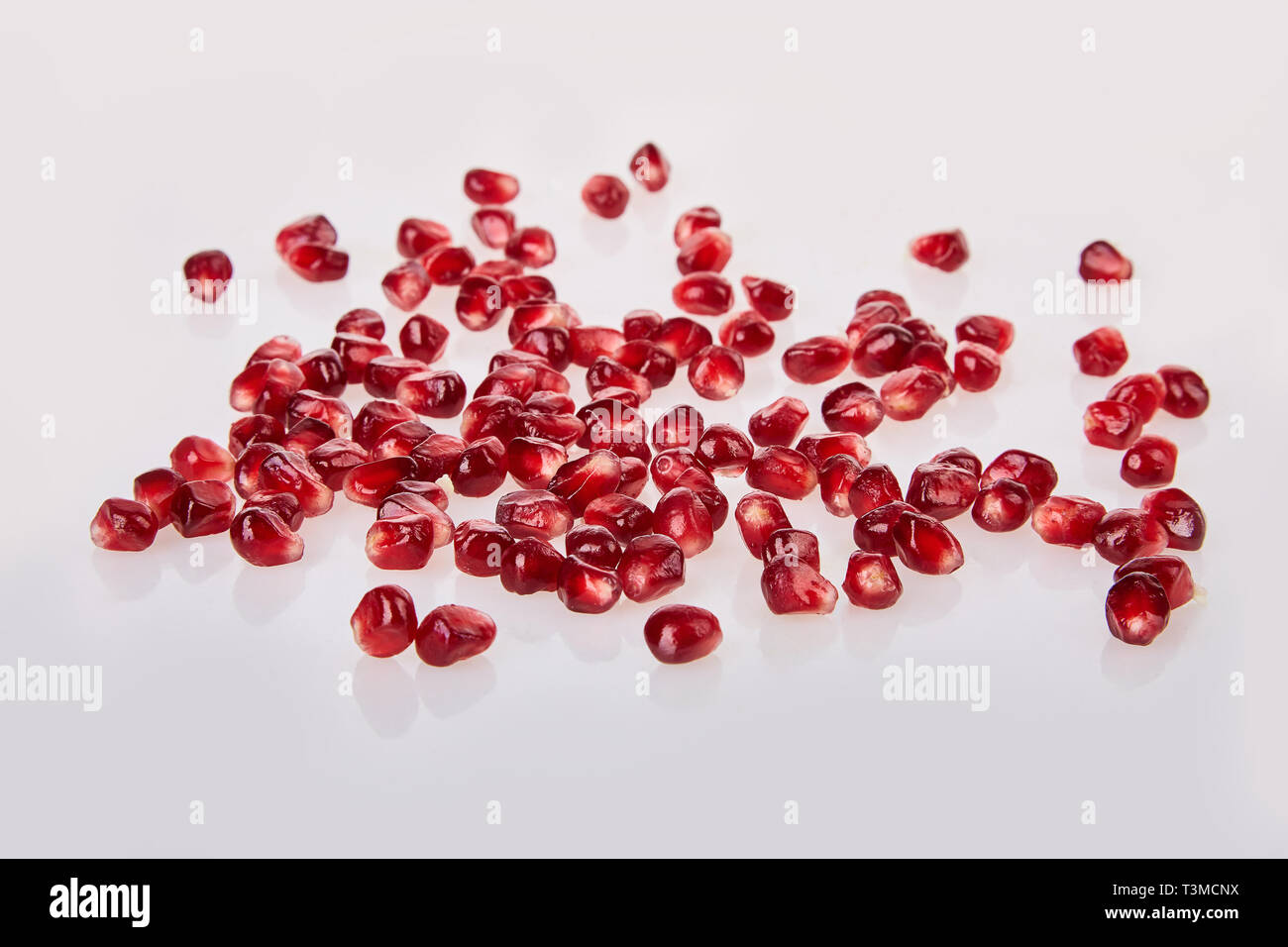 Close-up of pomegranate seeds texture on a white background, top view ...
