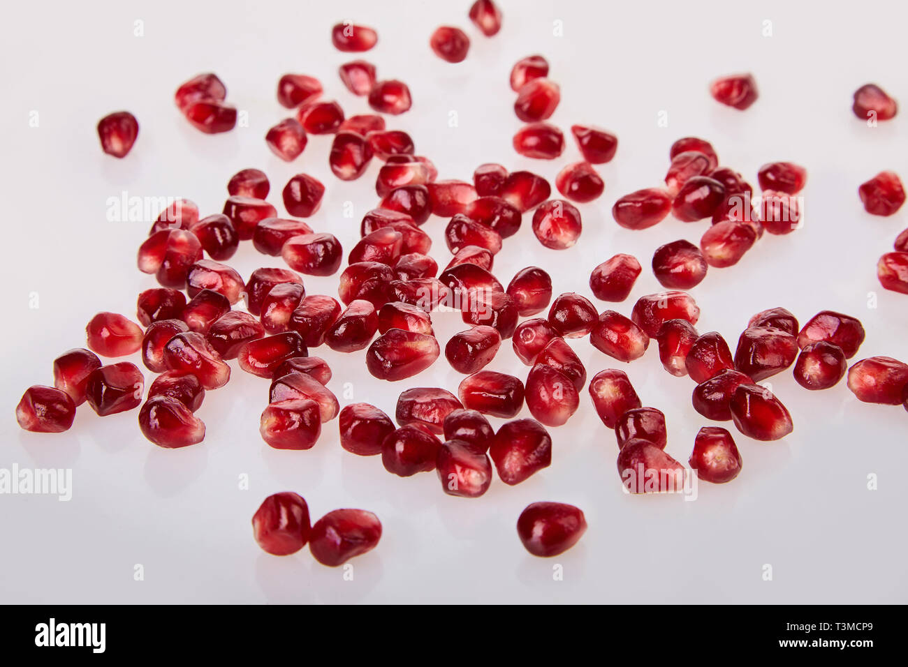 Close-up of pomegranate seeds texture on a white background, top view ...