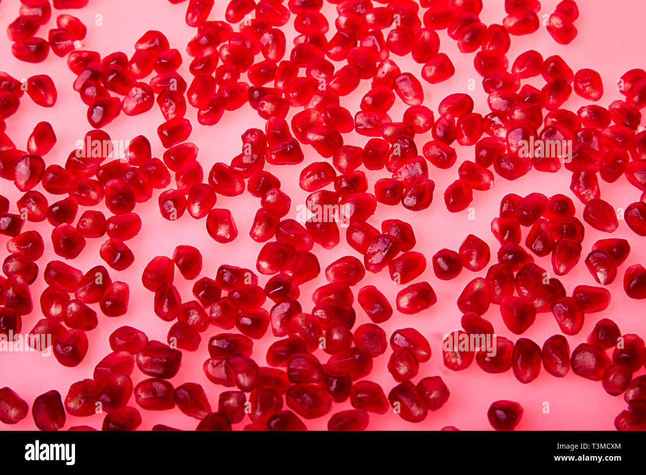 Close-up of pomegranate seeds texture on a white background, top view ...