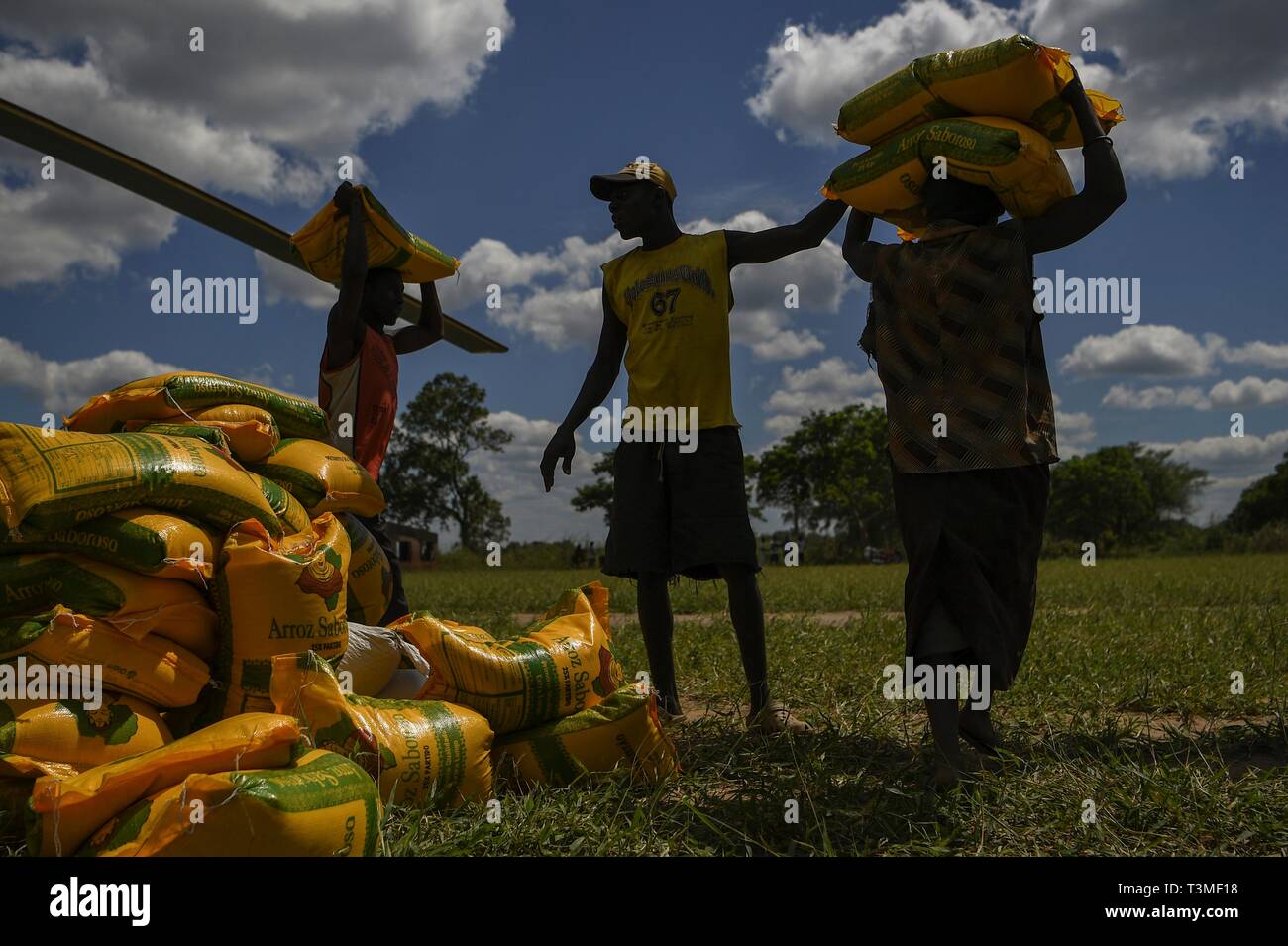 Local volunteers unload food aid from a U.S. Air Force helicopter in ...